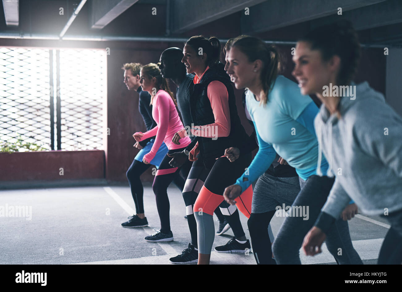 Side view of several athletes standing on starting line just before ...