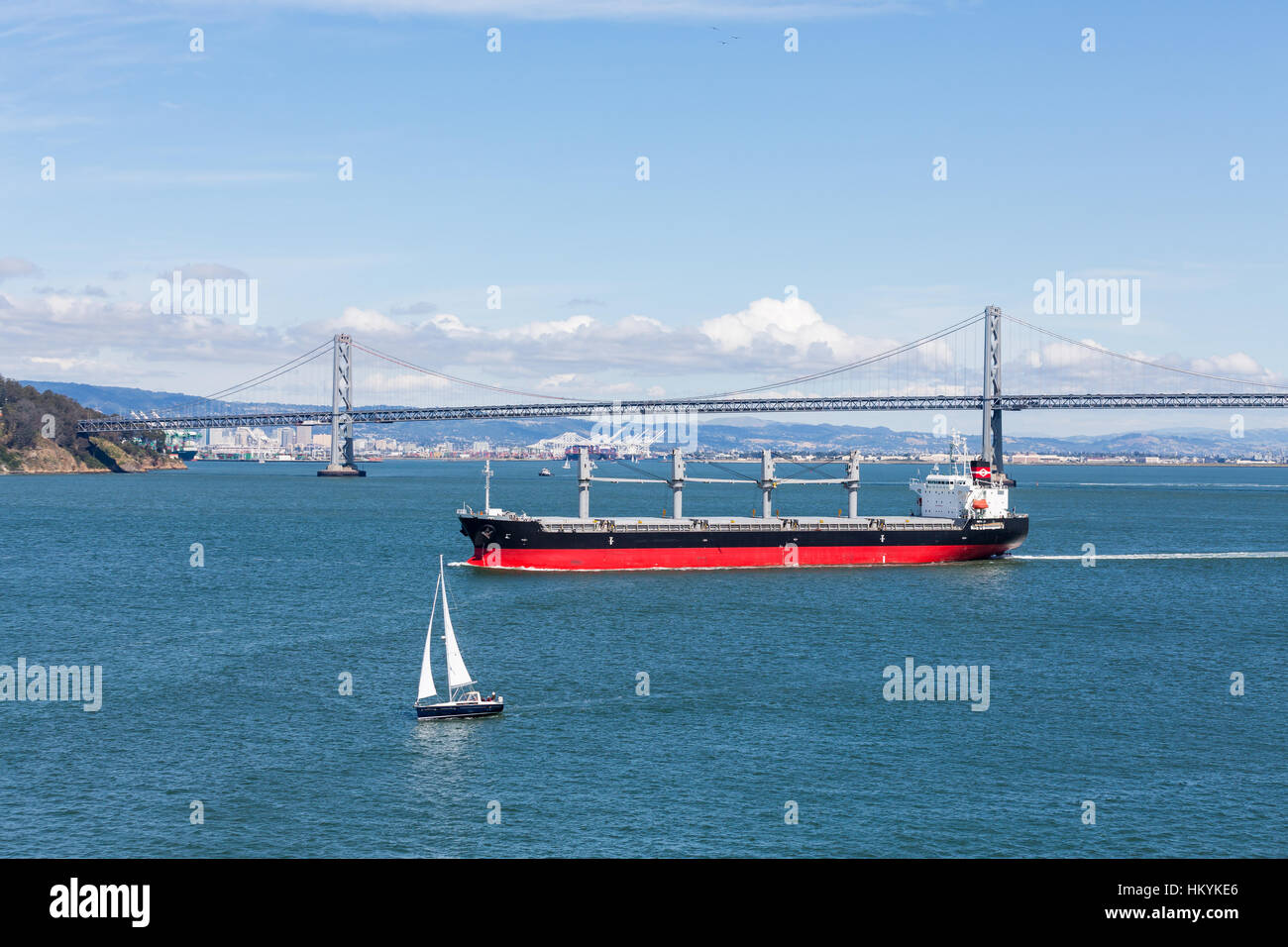 A massive freighter and small sailboat in the bay of San Francisco ...