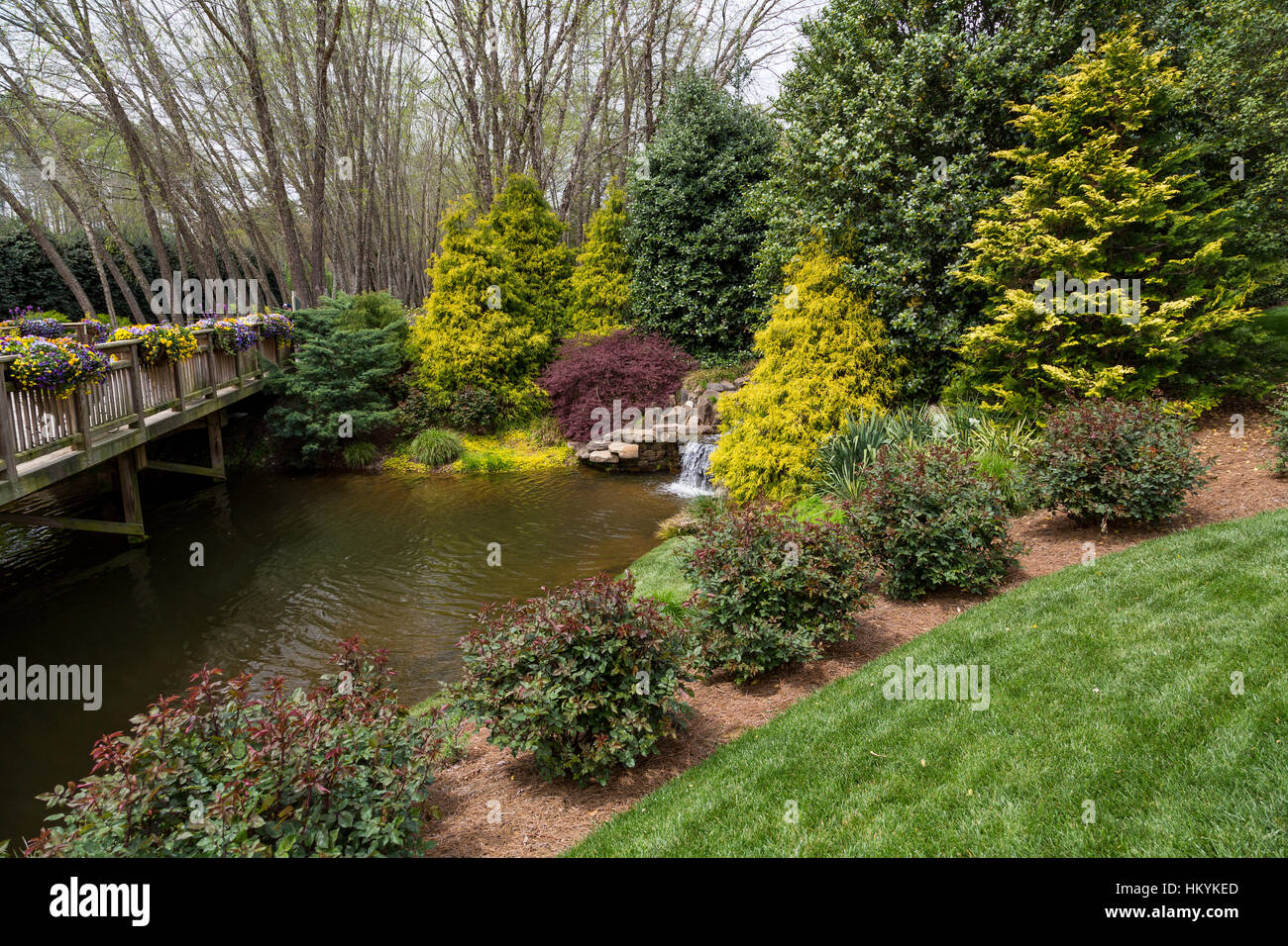 A Small Waterfall into Pond by Bridge Stock Photo - Alamy