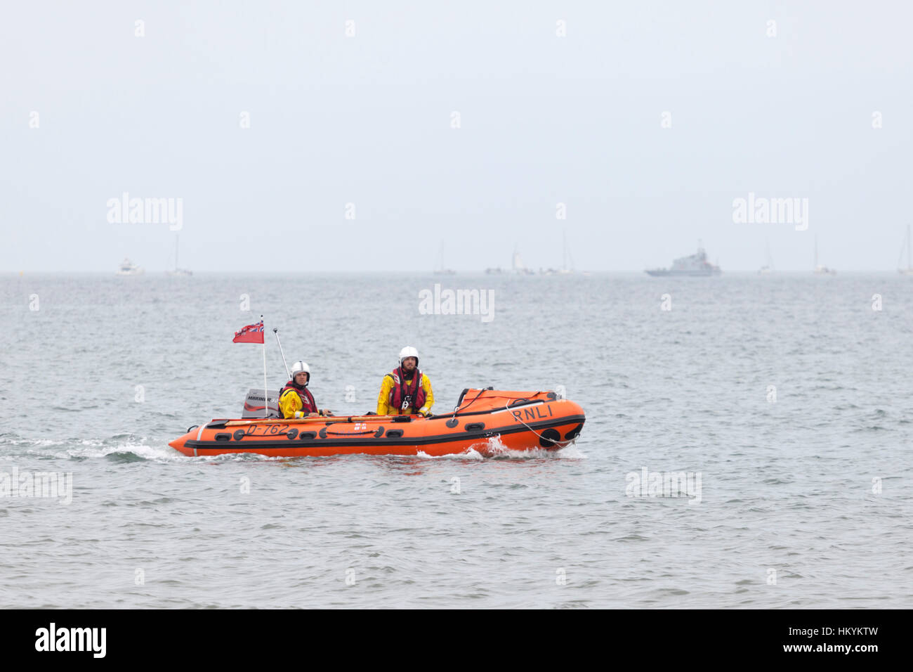 A British RNLI D Class inshore lifeboat patrolling just off the beach ...