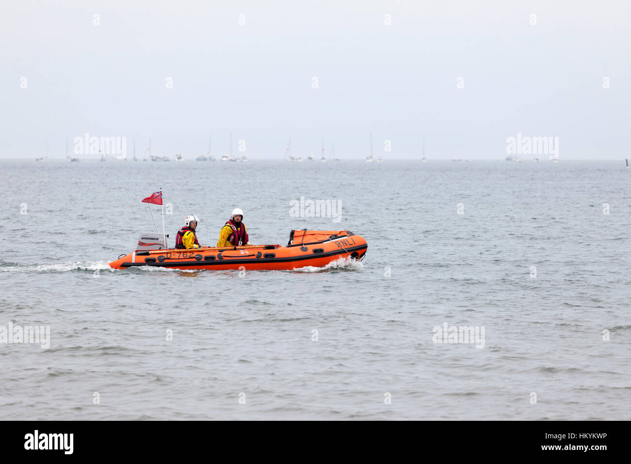 A British RNLI D Class inshore lifeboat patrolling just off the beach ...