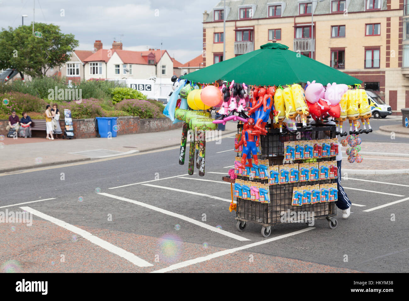 Toy seller with cart on a busy holiday street Stock Photo - Alamy