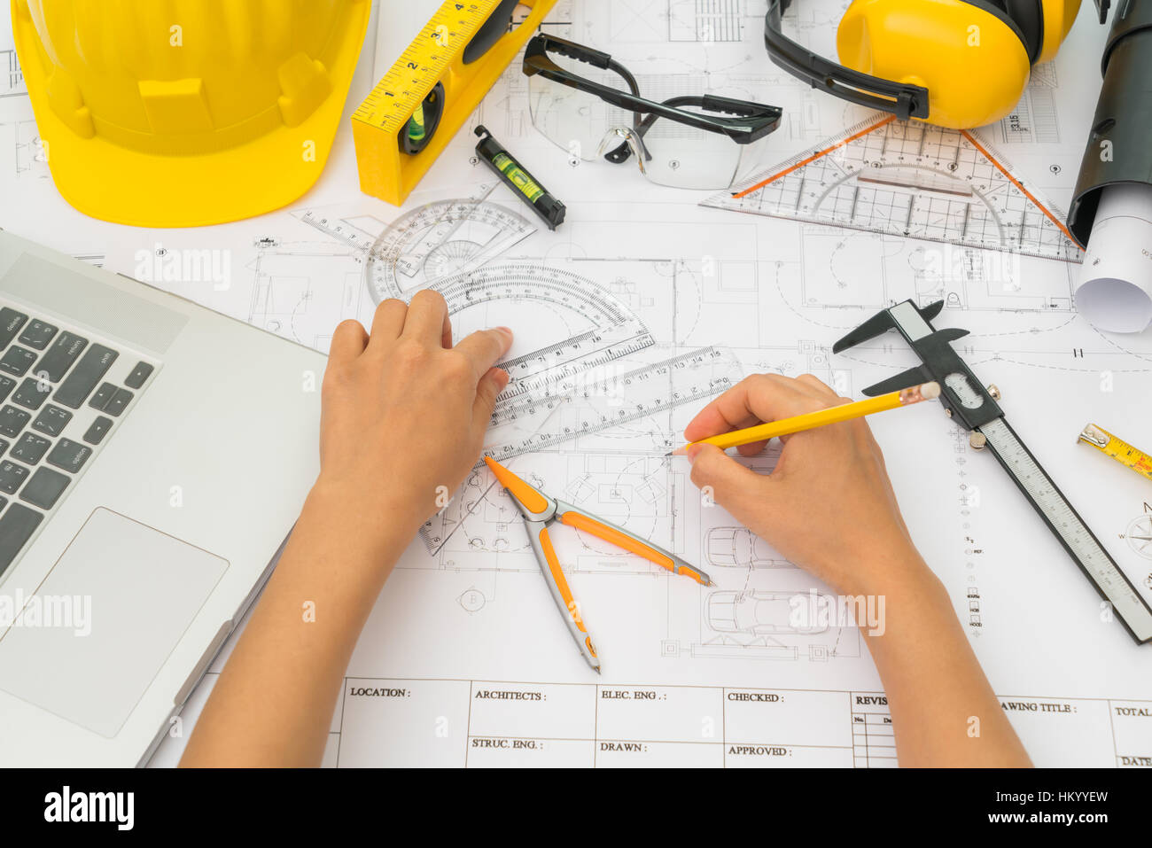 Hand over Construction plans with yellow helmet and drawing tools on ...