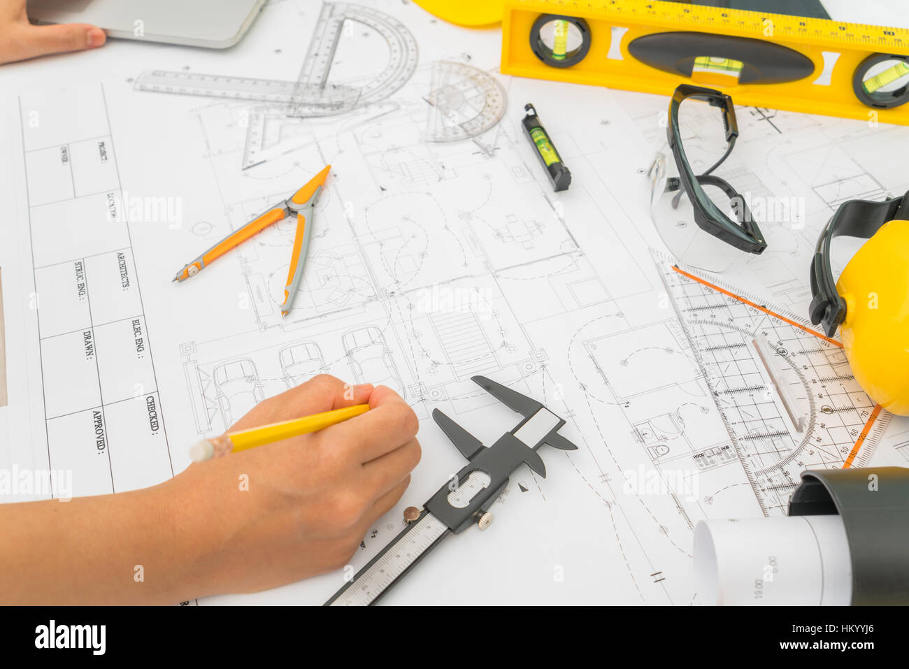 Hand over Construction plans with yellow helmet and drawing tools on ...