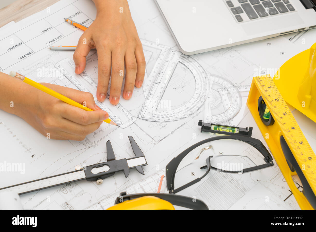 Hand over Construction plans with yellow helmet and drawing tools on ...