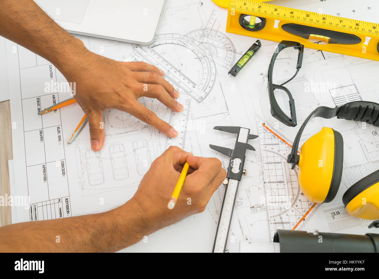 Hand over Construction plans with yellow helmet and drawing tools on ...