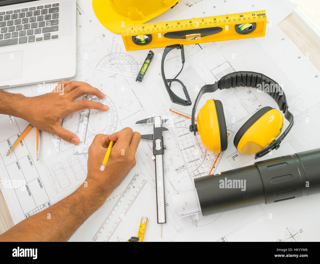 Hand over Construction plans with yellow helmet and drawing tools on ...