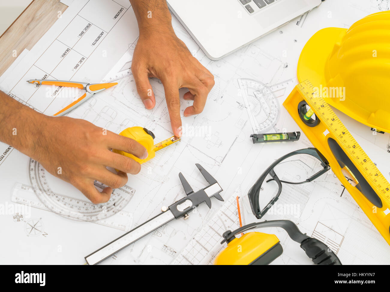 Hand over Construction plans with yellow helmet and drawing tools on ...