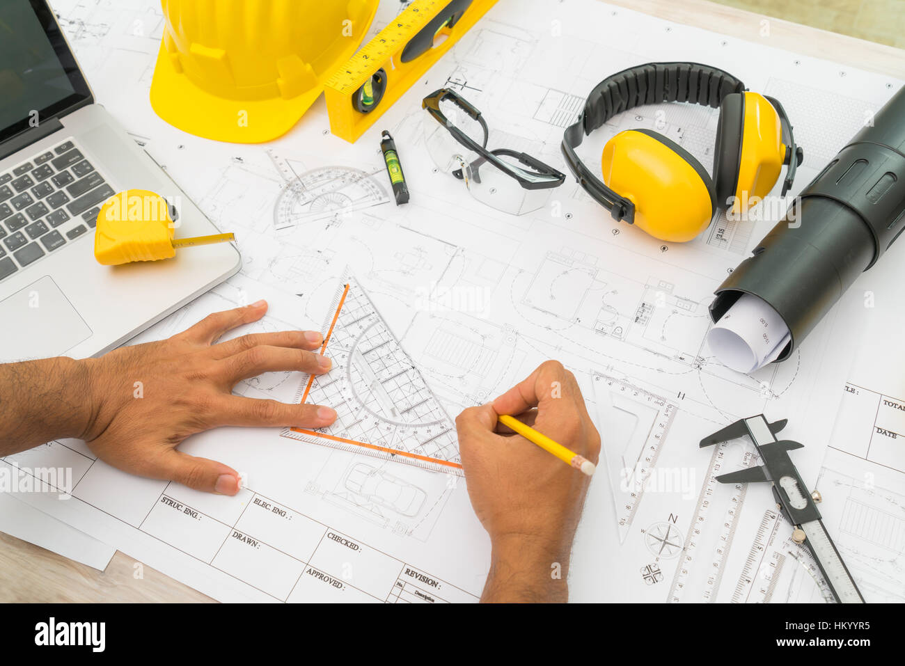 Hand over Construction plans with yellow helmet and drawing tools on ...
