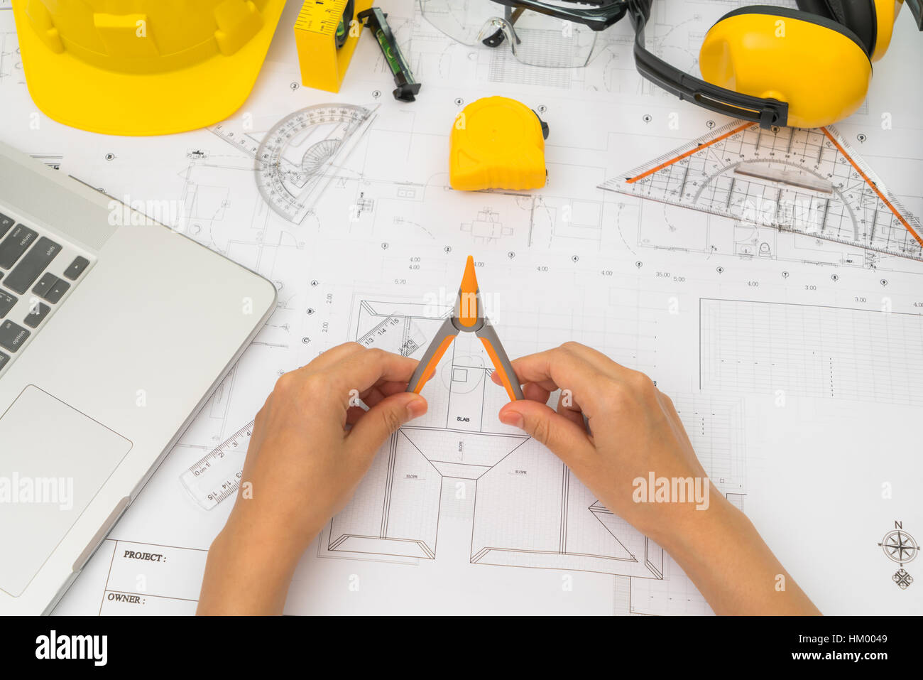 Hand over Construction plans with yellow helmet and drawing tools on ...