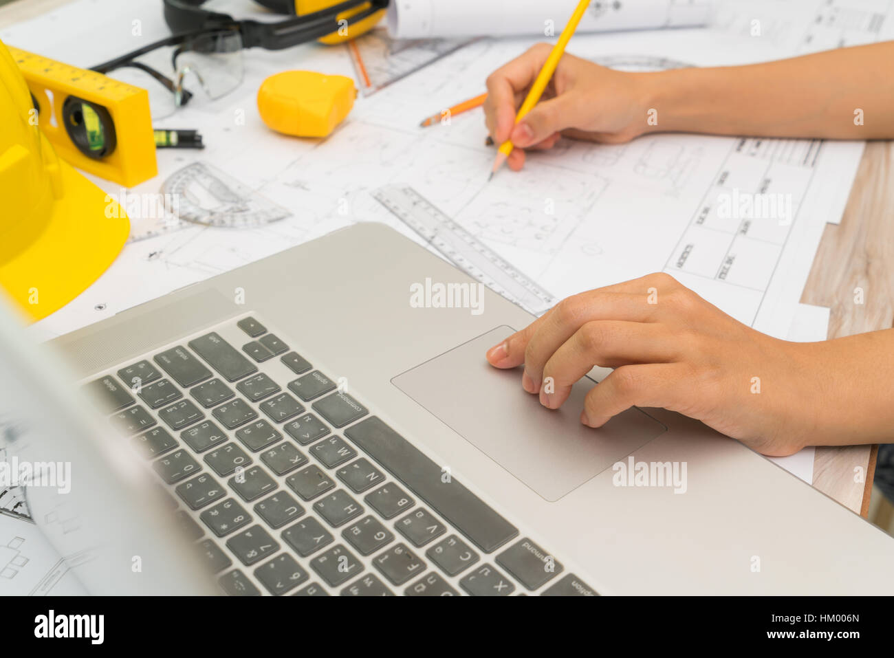Hand over Construction plans with yellow helmet and drawing tools on ...