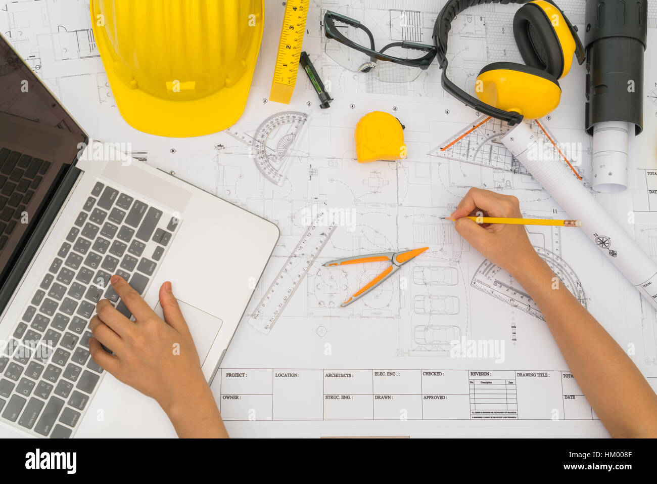 Hand over Construction plans with yellow helmet and drawing tools on ...