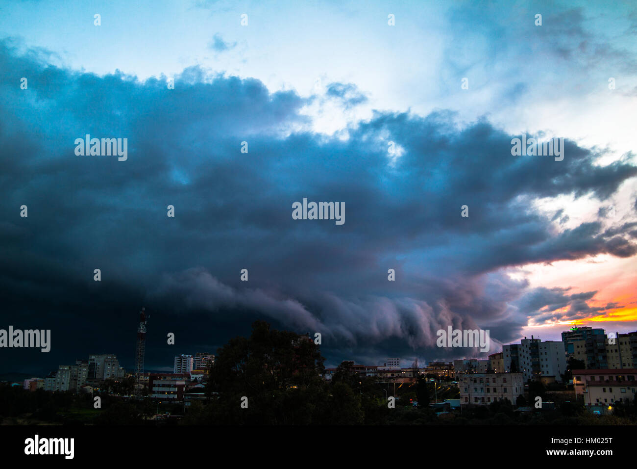 A big sky "wave" approaching the city and covering the sky at sunset ...
