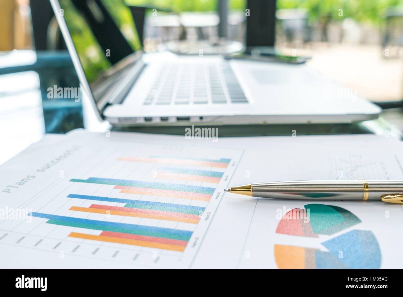 Financial charts on the table with laptop Stock Photo - Alamy