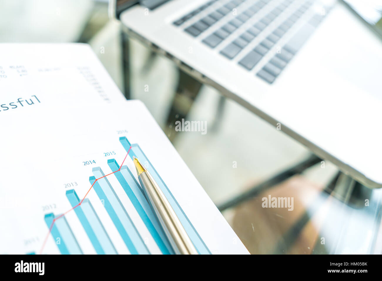 Financial charts on the table with laptop Stock Photo - Alamy