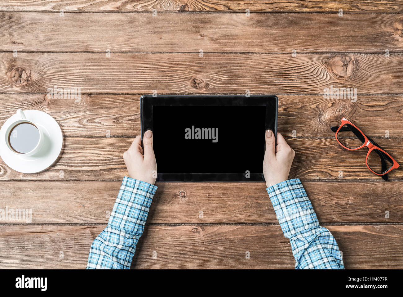 Top view of woman sitting at wooden table and working with table Stock ...