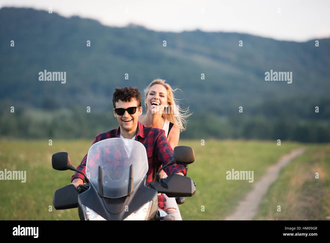 Couple in love enjoying a motorbike ride in countryside Stock Photo - Alamy