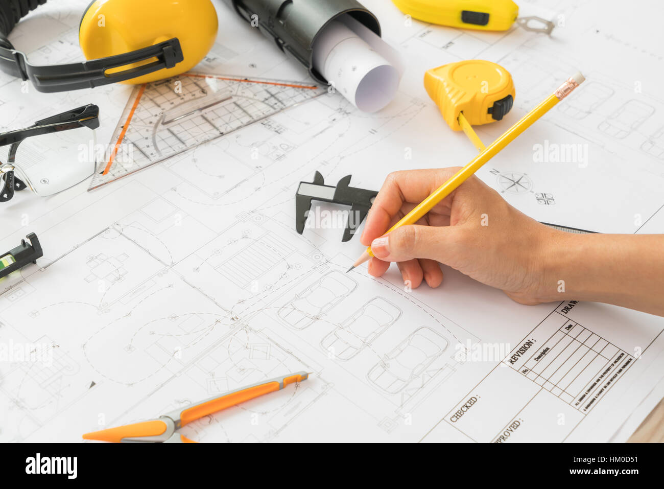 Hand over Construction plans with yellow helmet and drawing tools on ...