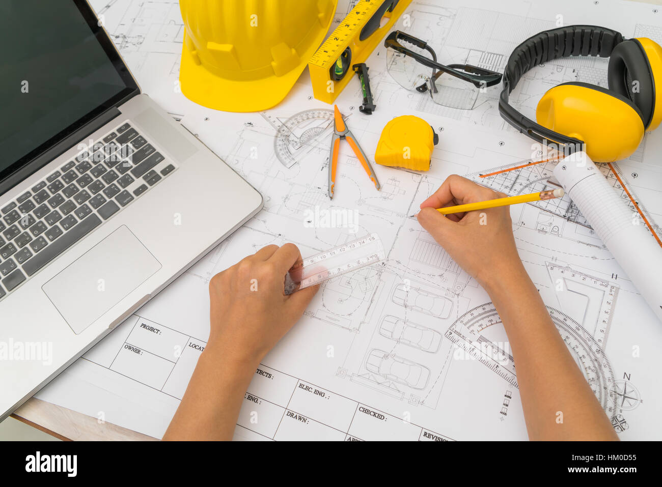 Hand over Construction plans with yellow helmet and drawing tools on ...
