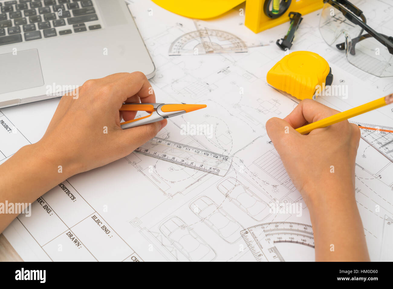 Hand over Construction plans with yellow helmet and drawing tools on ...
