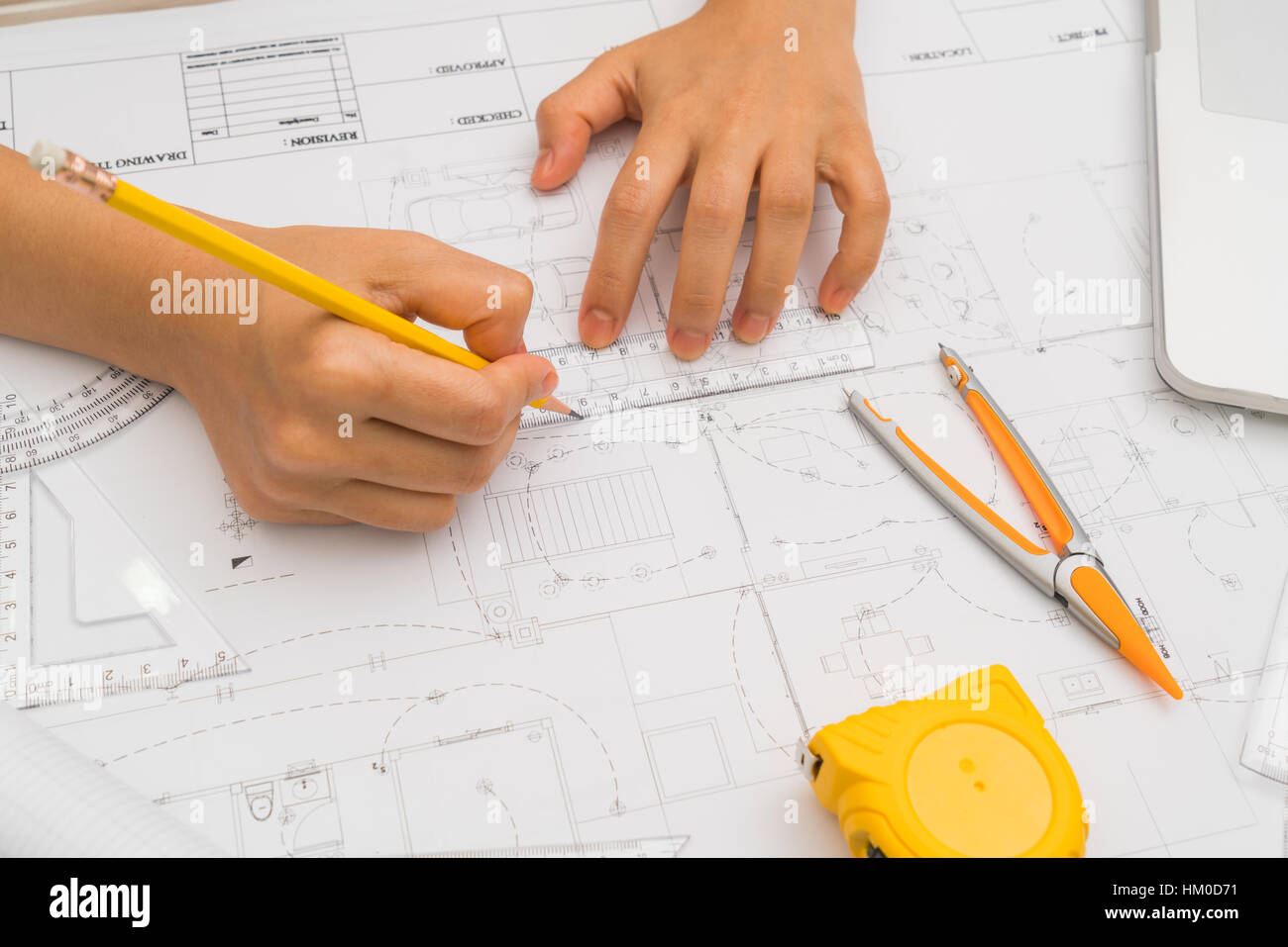 Hand over Construction plans with yellow helmet and drawing tools on ...