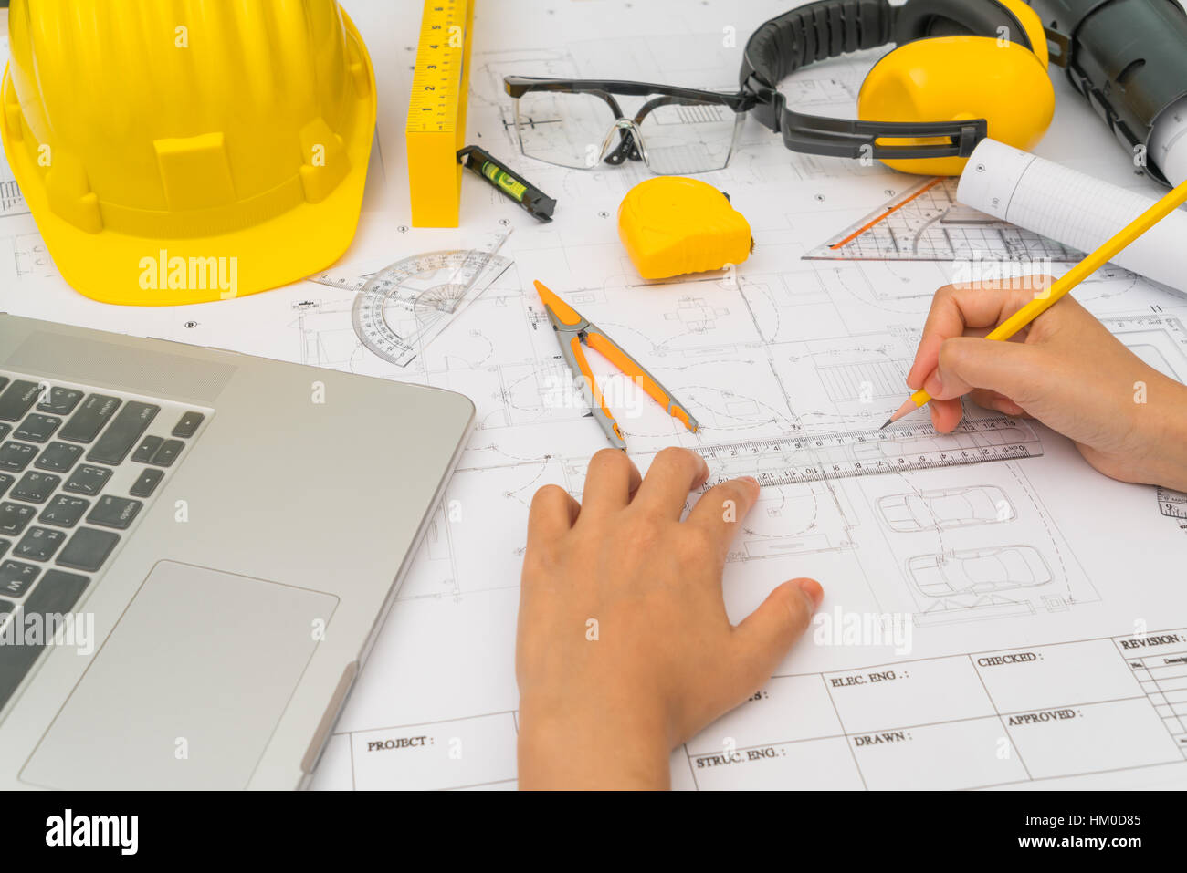Hand over Construction plans with yellow helmet and drawing tools on ...