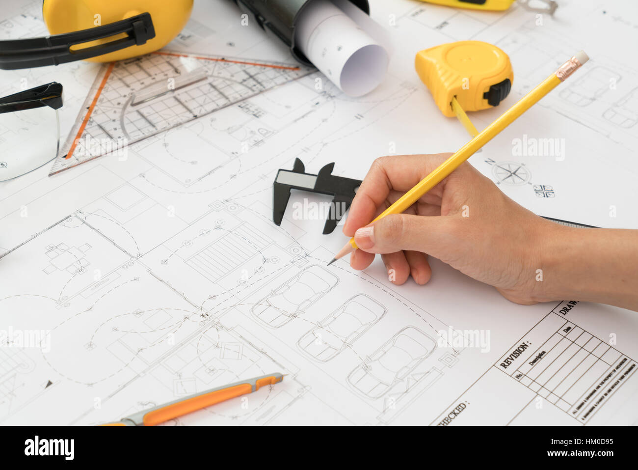 Hand over Construction plans with yellow helmet and drawing tools on ...