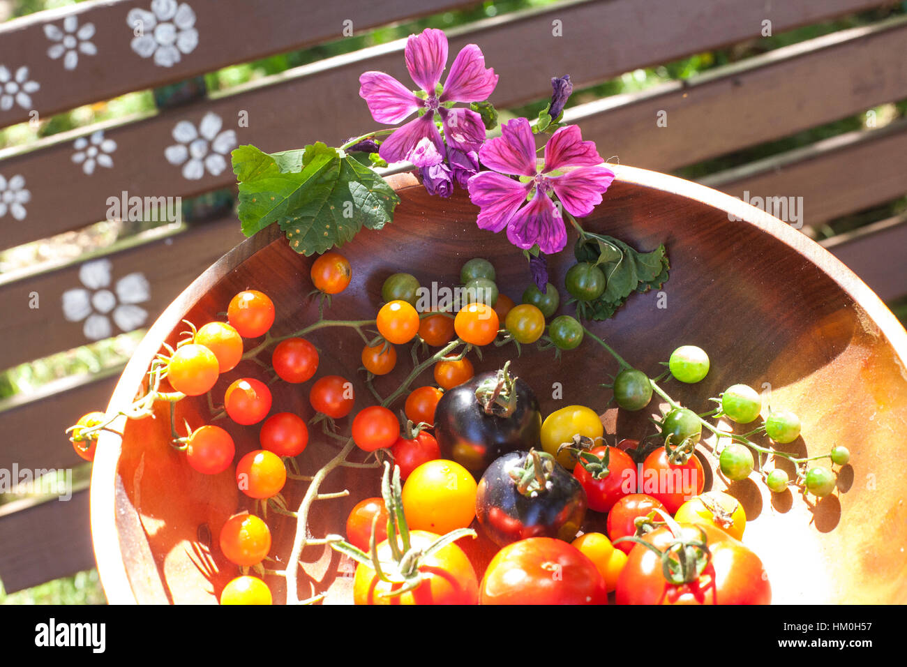 Creative variety of heirloom tomatoes in a rustic bowl and on a light ...