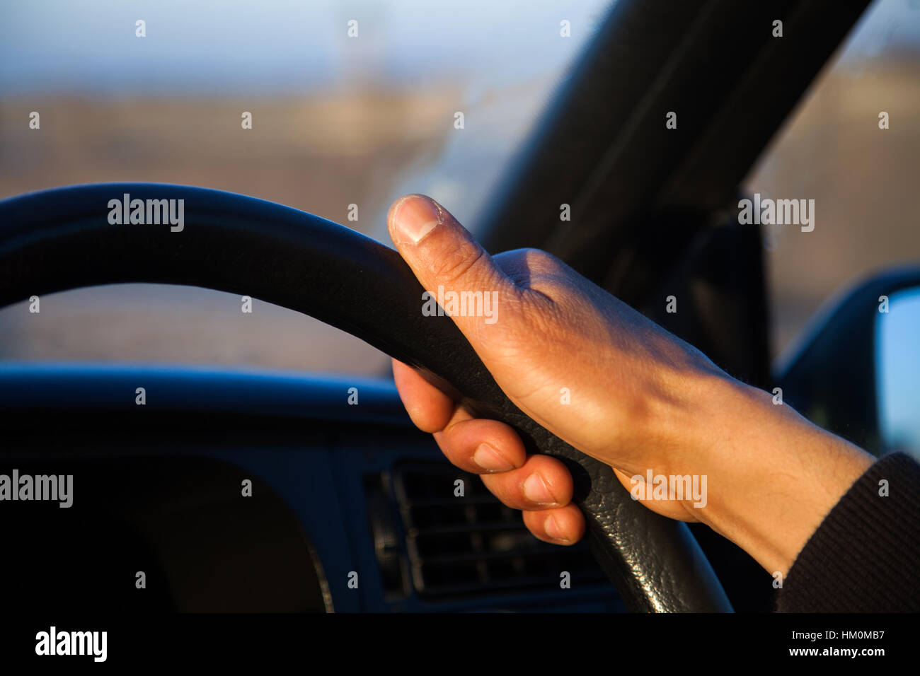 male hands on wheel driving a car Stock Photo - Alamy