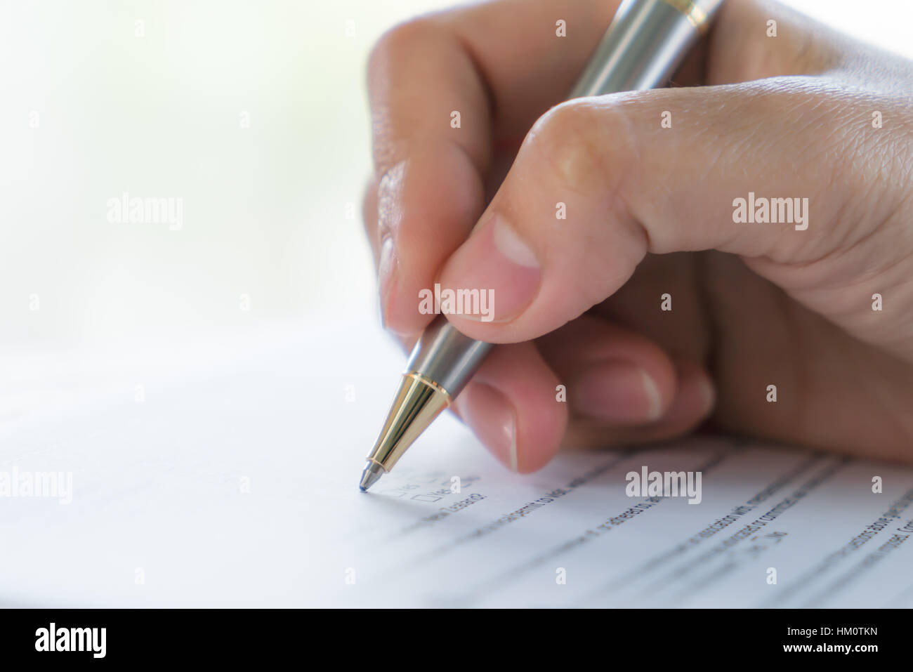 Hand with pen over application form Stock Photo - Alamy