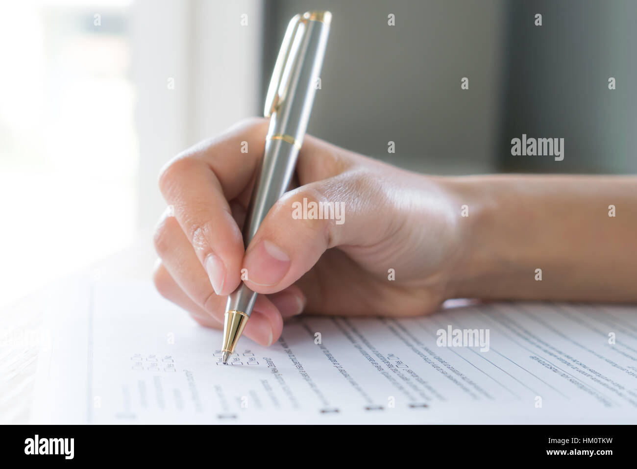 Hand with pen over application form Stock Photo - Alamy
