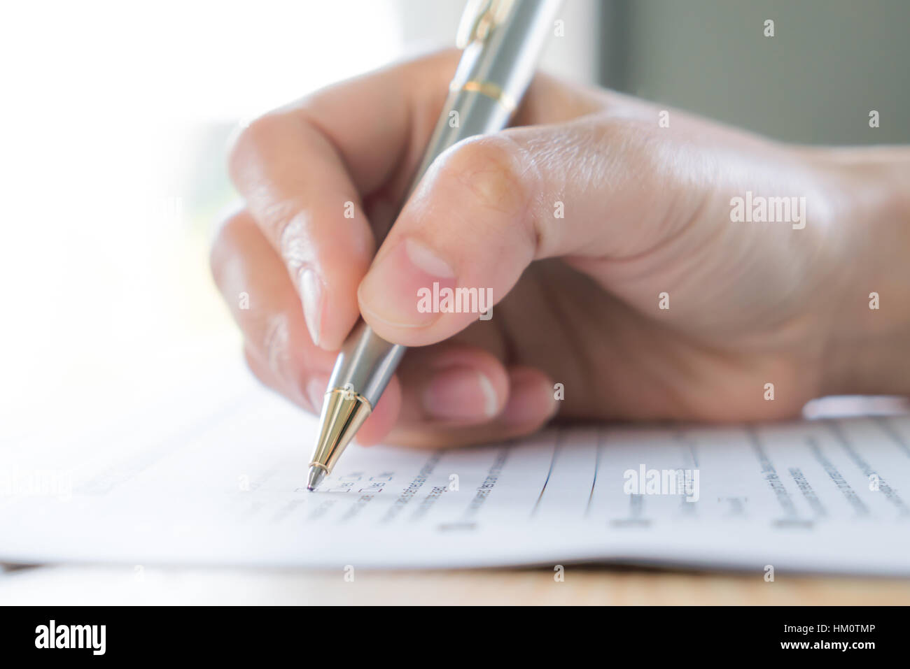 Hand with pen over application form Stock Photo - Alamy