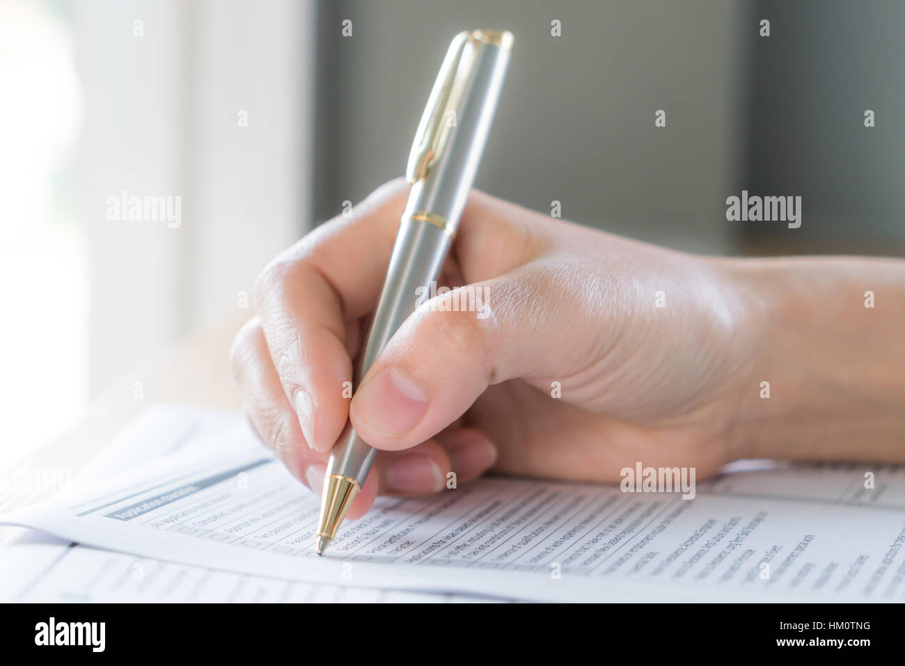 Hand with pen over application form Stock Photo - Alamy
