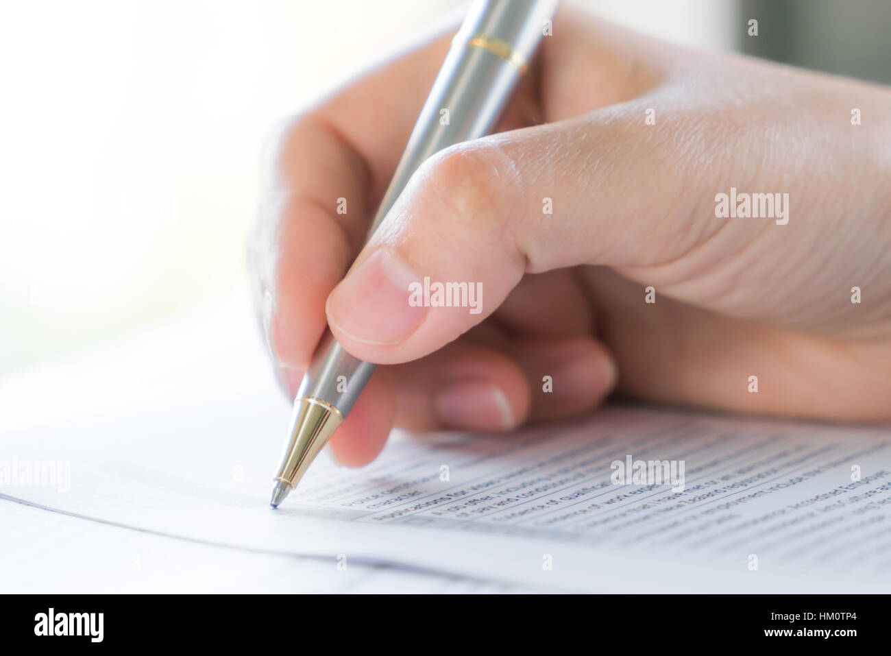 Hand with pen over application form Stock Photo - Alamy