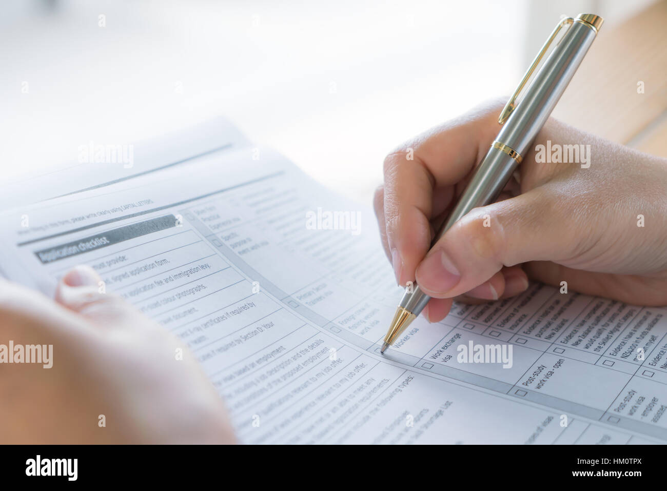 Hand with pen over application form Stock Photo - Alamy