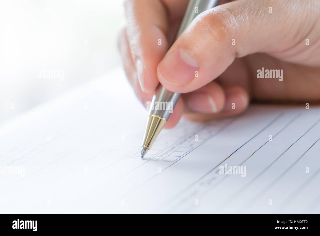 Hand with pen over application form Stock Photo - Alamy