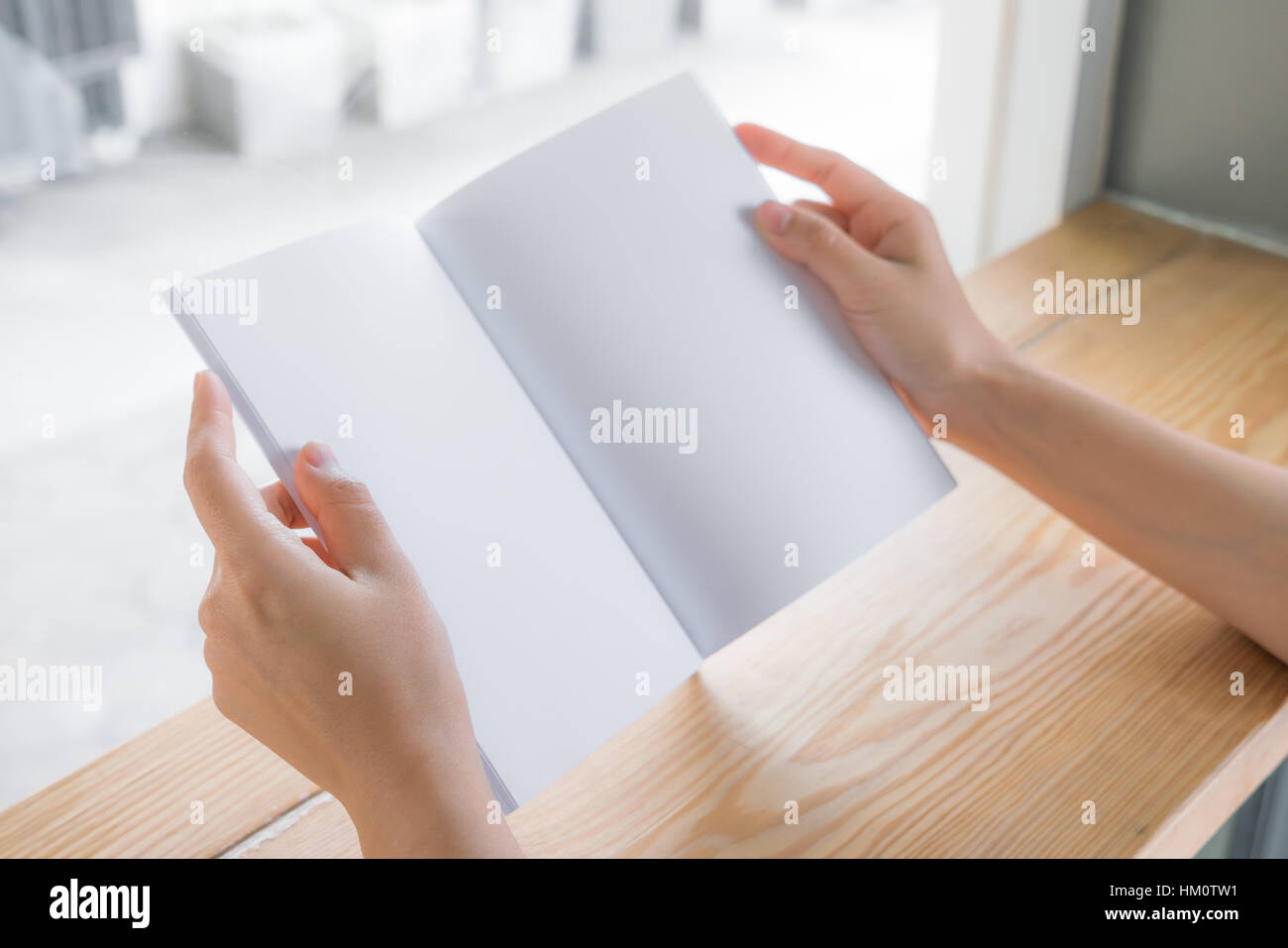 Hands open book on wood table Stock Photo - Alamy