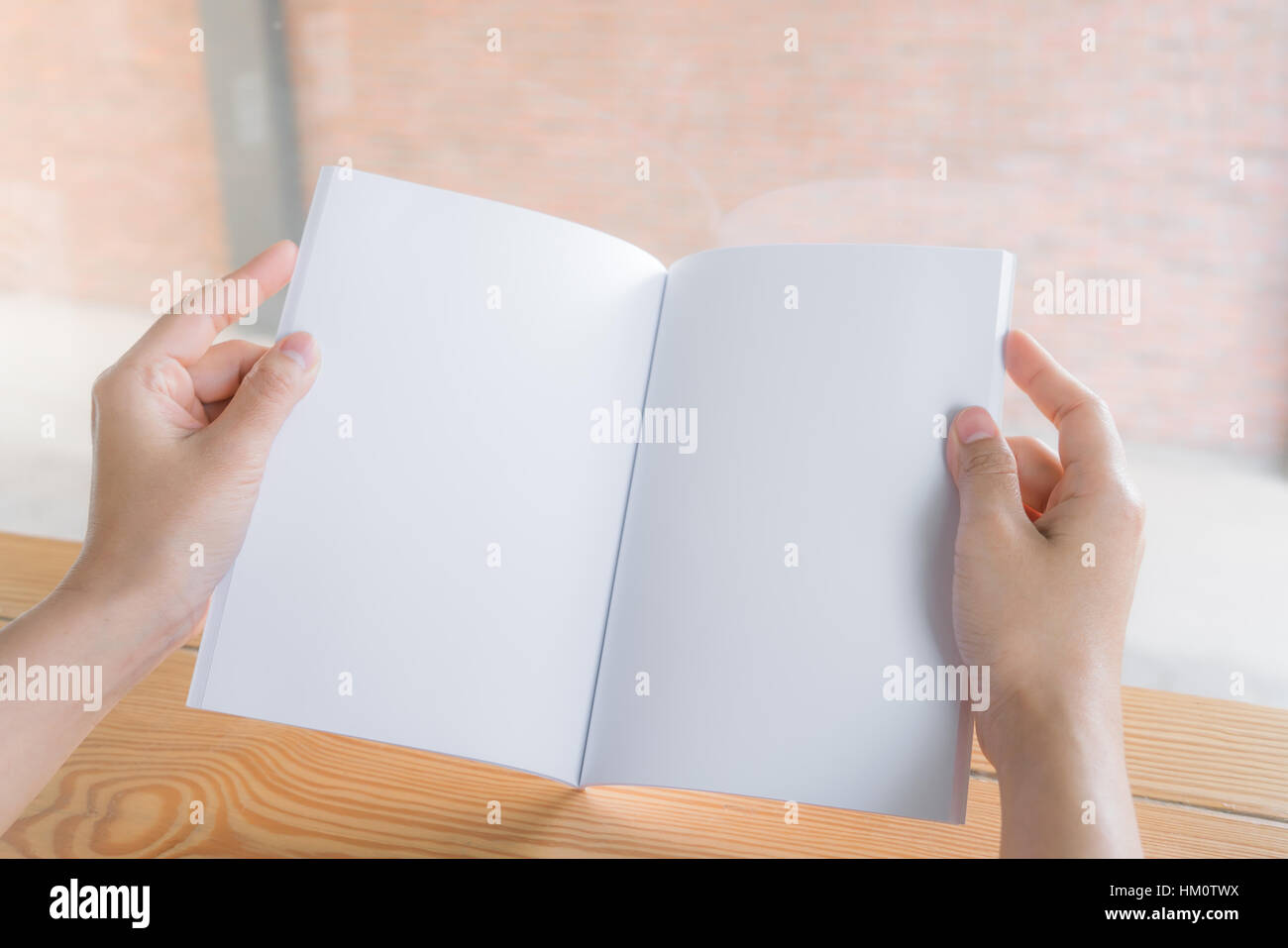 Hands open book on wood table Stock Photo - Alamy