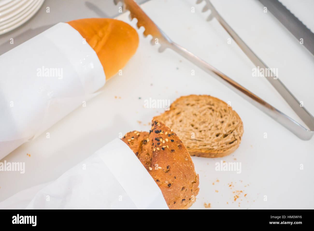 Fresh bread slice and cutting knife on table in buffet Stock Photo - Alamy
