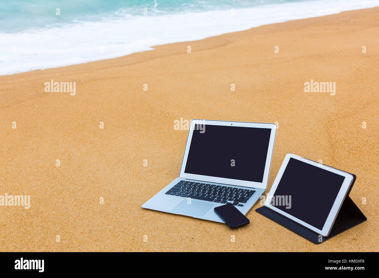Laptop ,tablet and smartphone on the beach in summer time Stock Photo ...