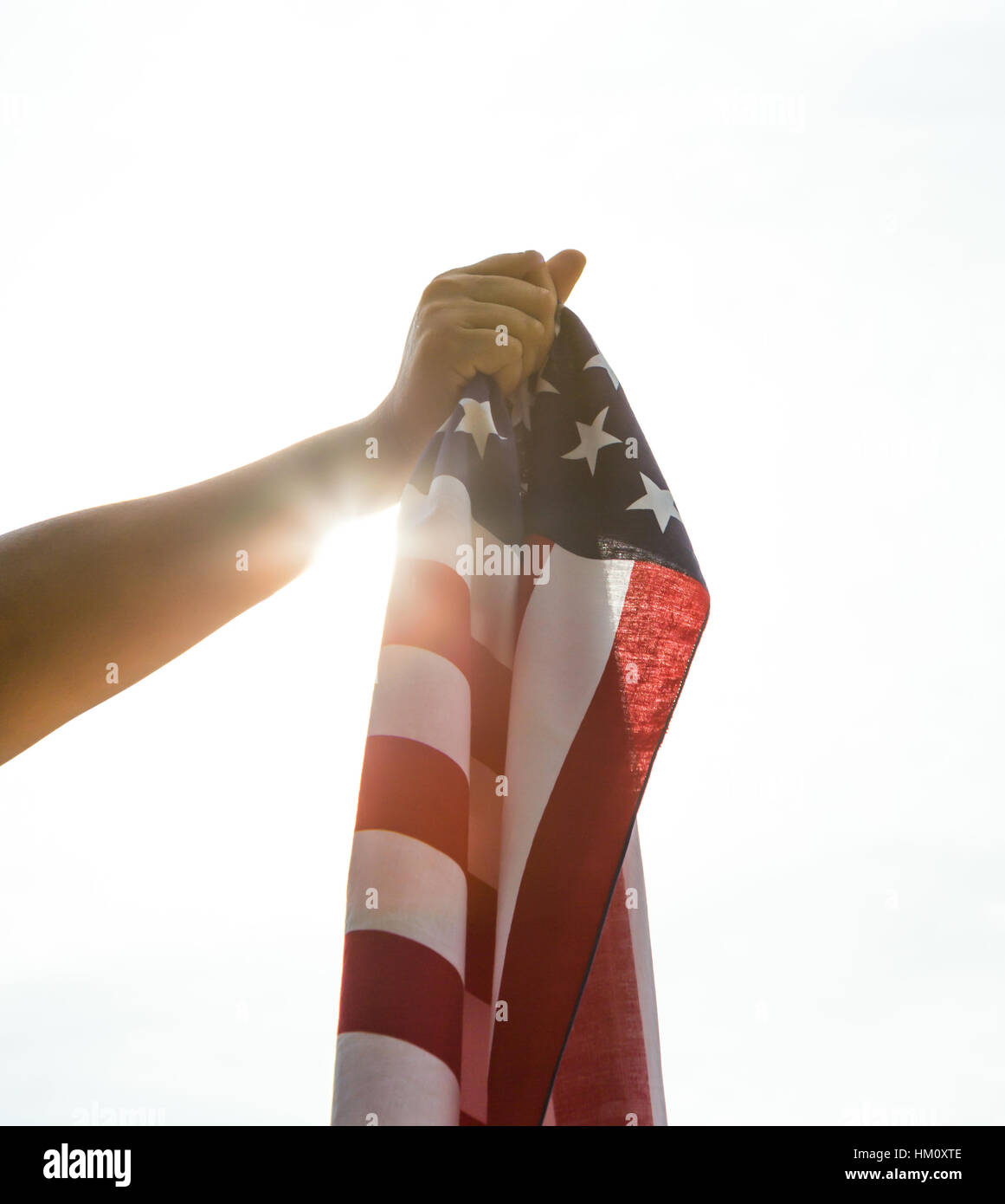 Hand hold American flag with sun light Stock Photo - Alamy