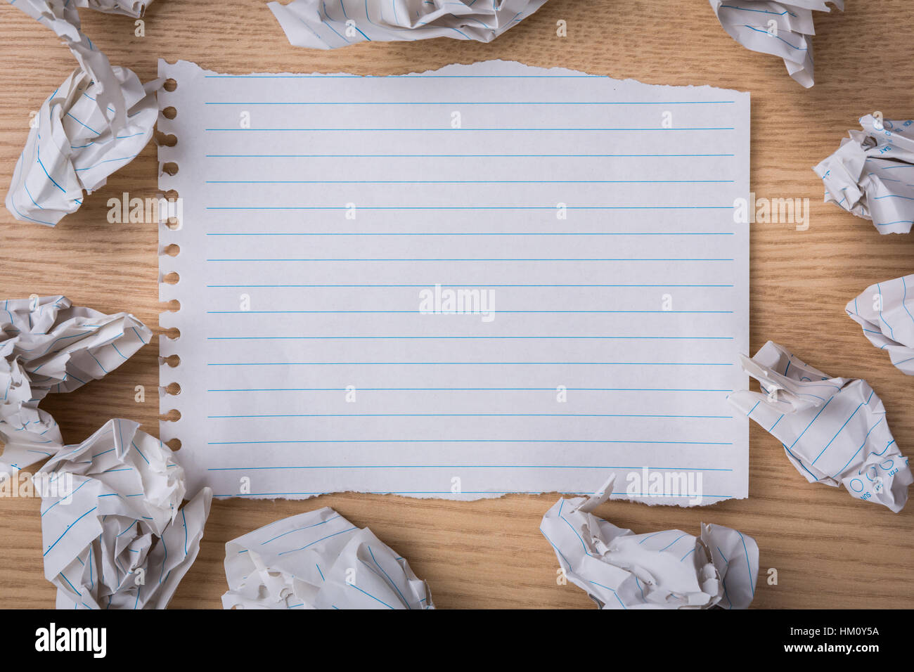White note book paper with pencil and crumpled paper on a wooden desk ...