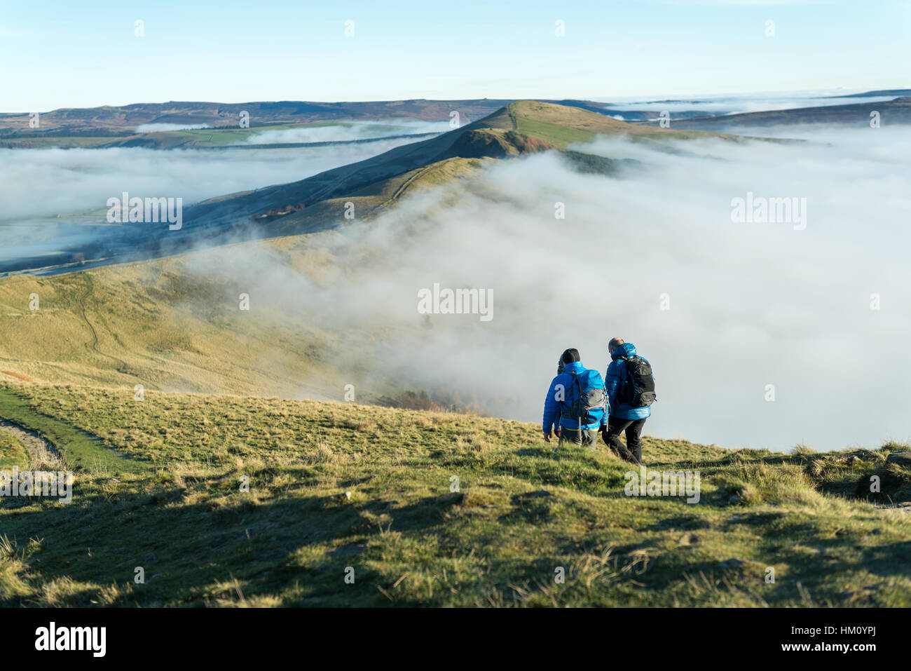 Male and female hikers walk along the great ridge along from Mam Tor ...