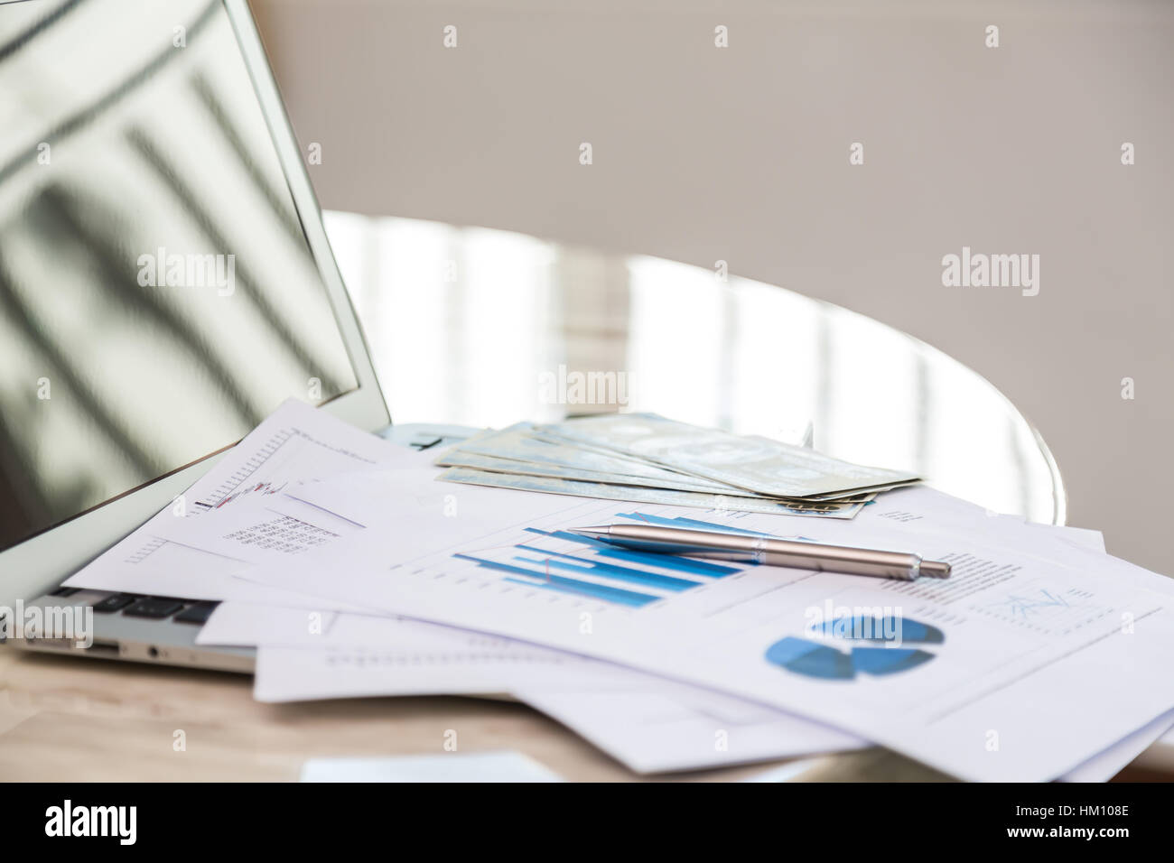 Financial charts on the table with laptop Stock Photo - Alamy