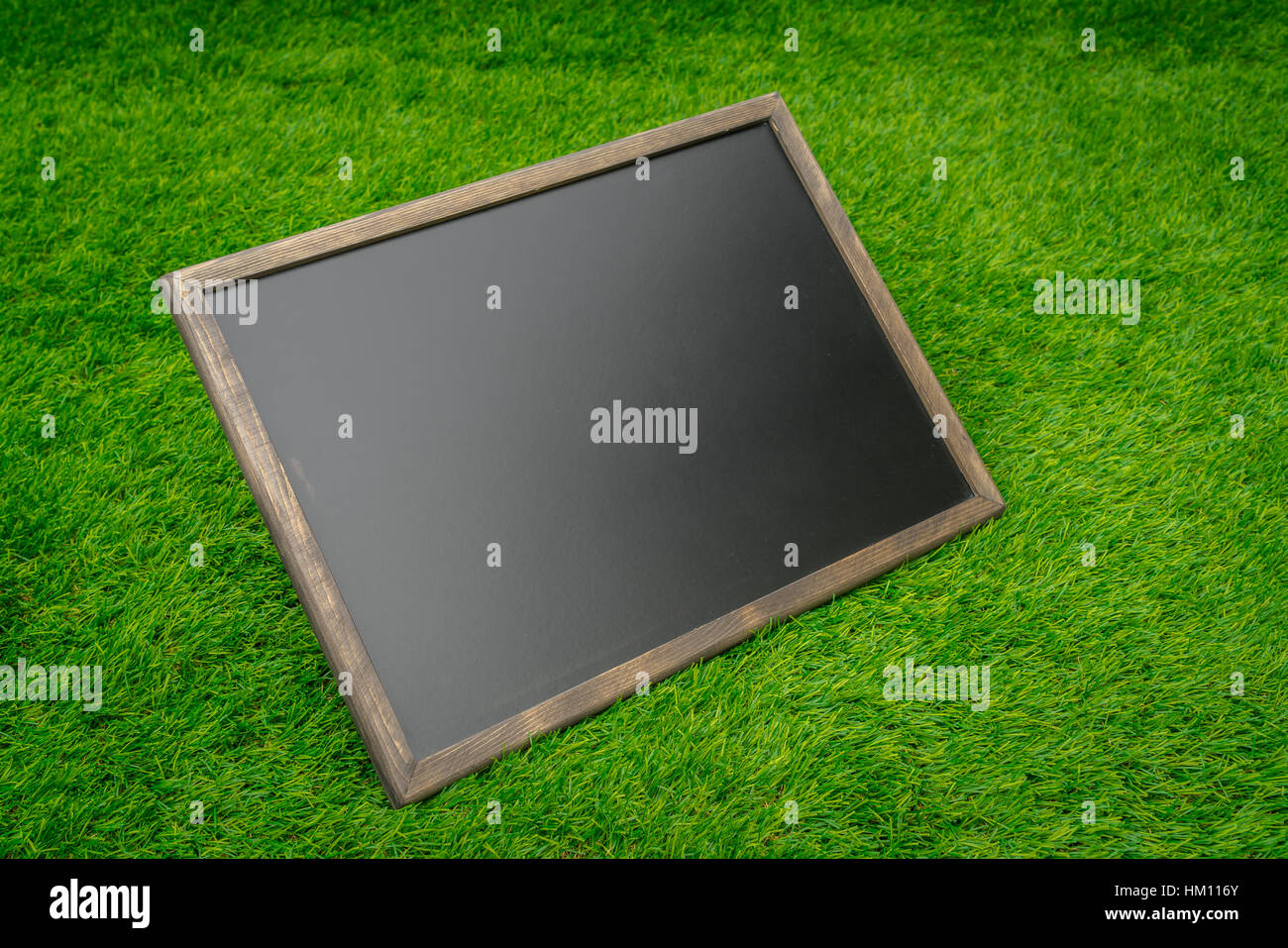 Blank black board on grass field Stock Photo - Alamy