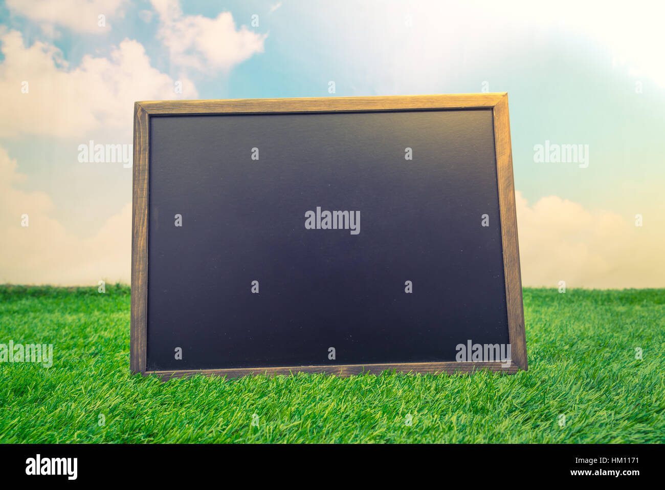 Blank black board on grass field Stock Photo - Alamy