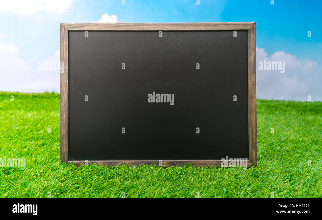 Blank black board on grass field Stock Photo - Alamy