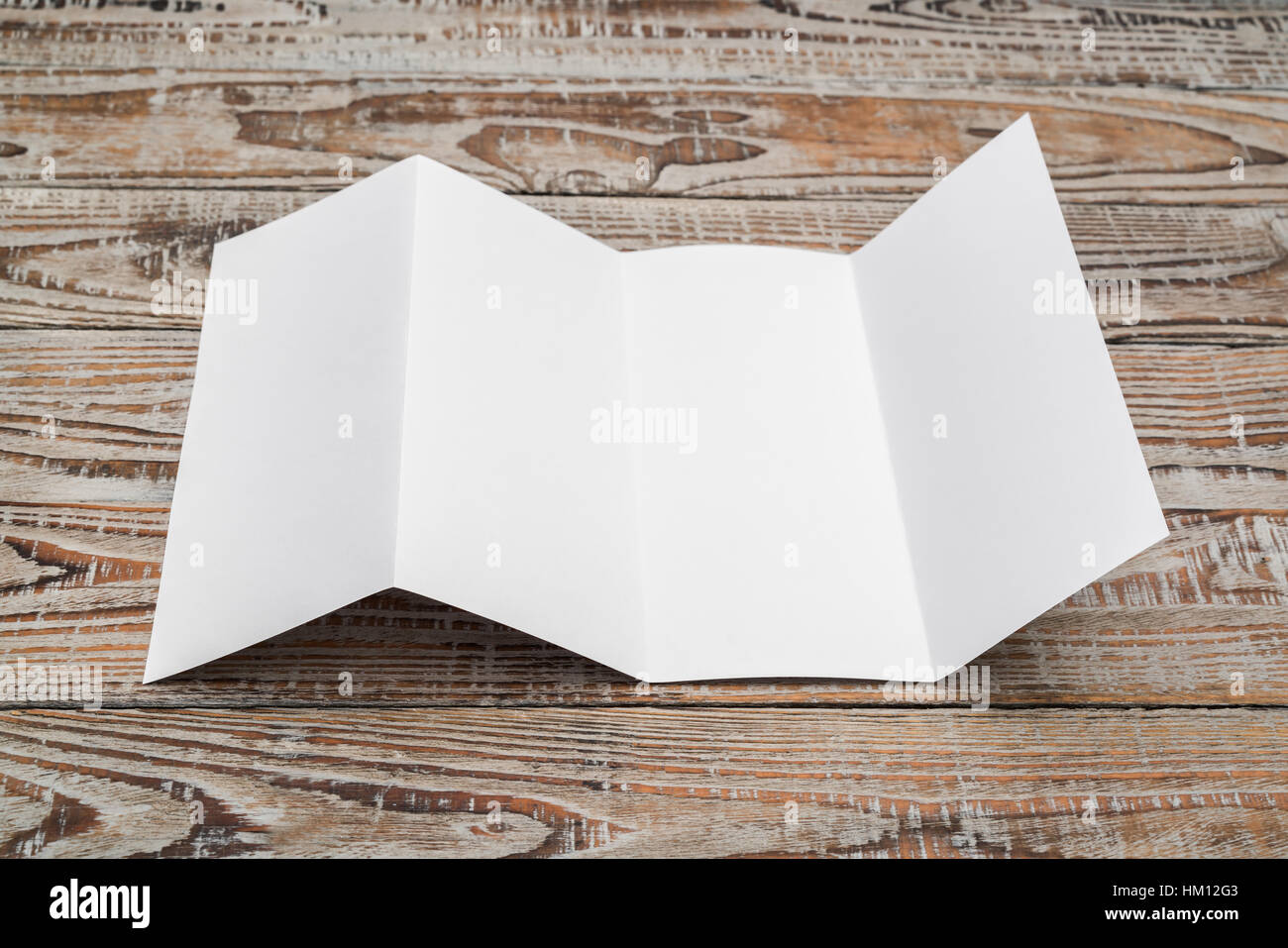 Four - fold white template paper on wood texture Stock Photo - Alamy