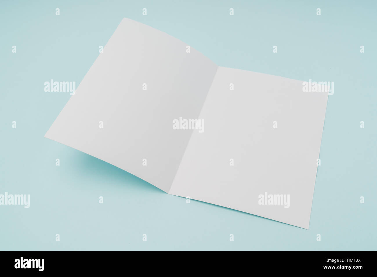 Bifold white template paper on blue background Stock Photo - Alamy