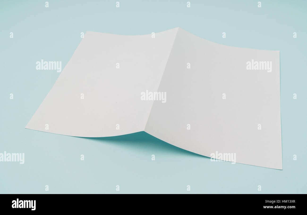 Bifold white template paper on blue background Stock Photo - Alamy